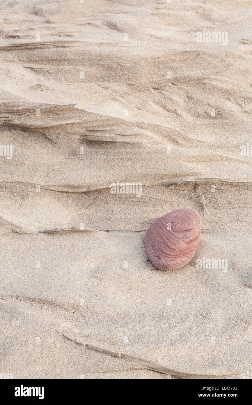 A red pebble on a sandy beach Stock Photo - Alamy