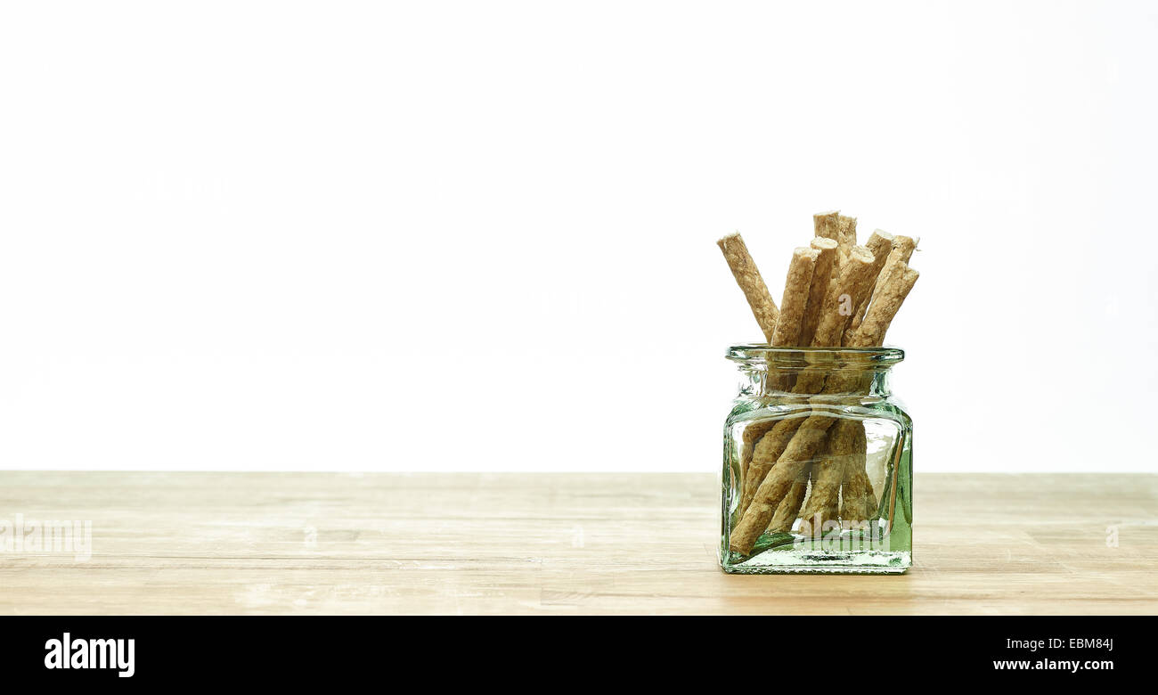The dog tidbits and a glass container on the wooden table, white ...
