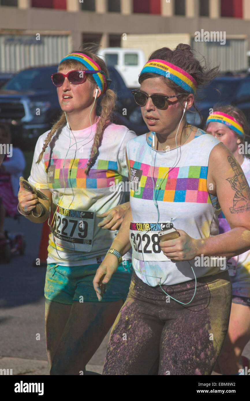 Women runners splattered with colorful dyes run in the the happy ...