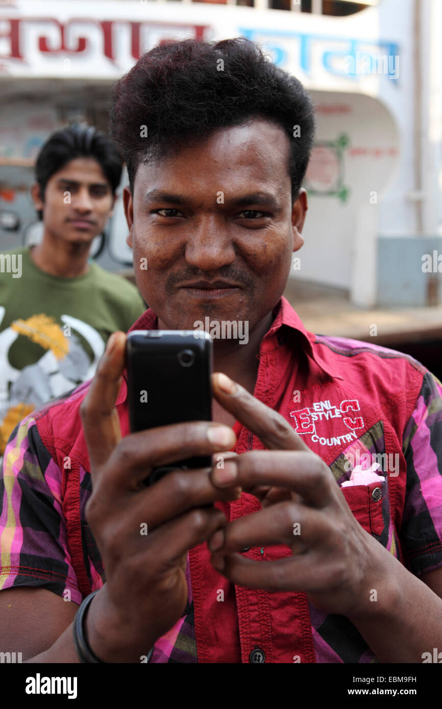 A man photographs using his mobile phone at Sadarghat Boat Terminal in ...