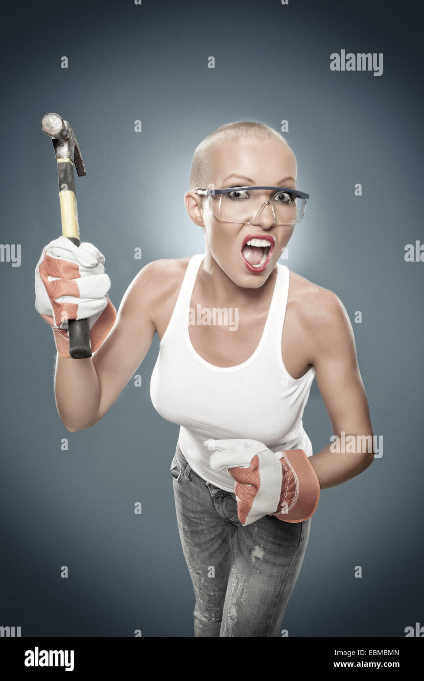 portrait of young beautiful woman with hammer on color back Stock Photo ...