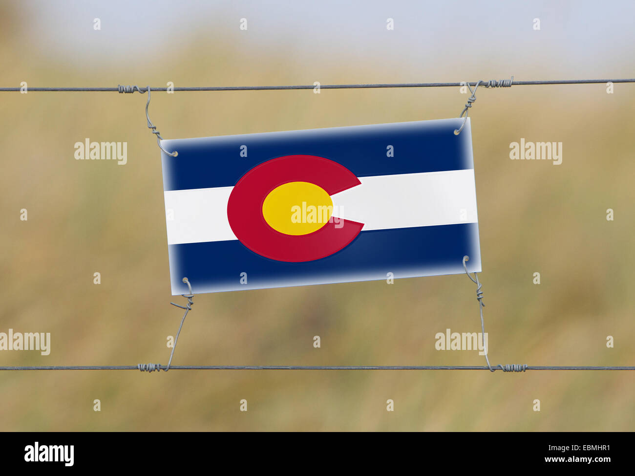Border fence - Old plastic sign with a flag - Colorado Stock Photo - Alamy