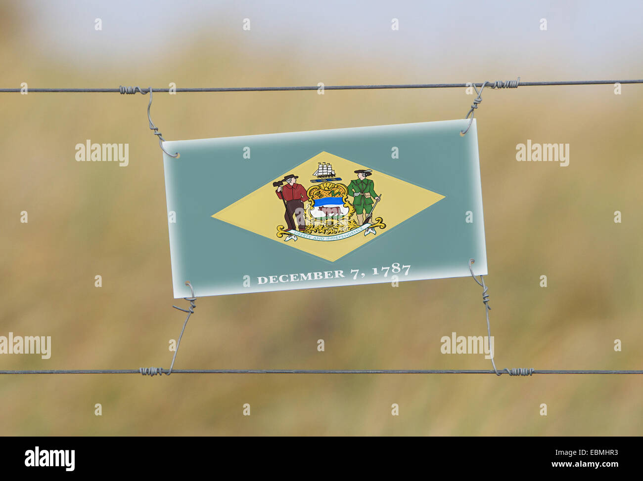 Border fence - Old plastic sign with a flag - Delaware Stock Photo - Alamy