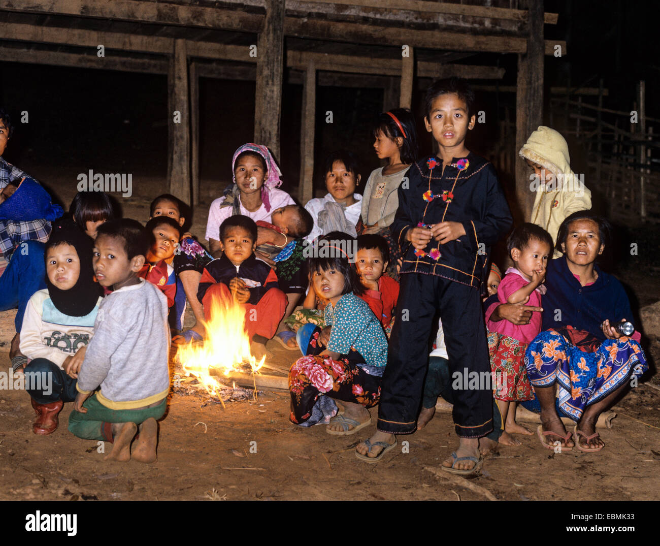 Lahu children sitting around a campfire in a mountain village, harvest ...