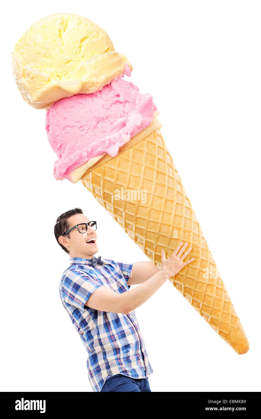 Cheerful young man carrying an enormous ice cream isolated on white ...