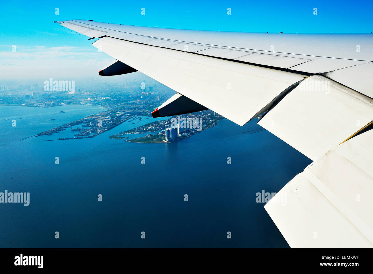Wing of a plane and views of the port area of Jakarta on landing ...