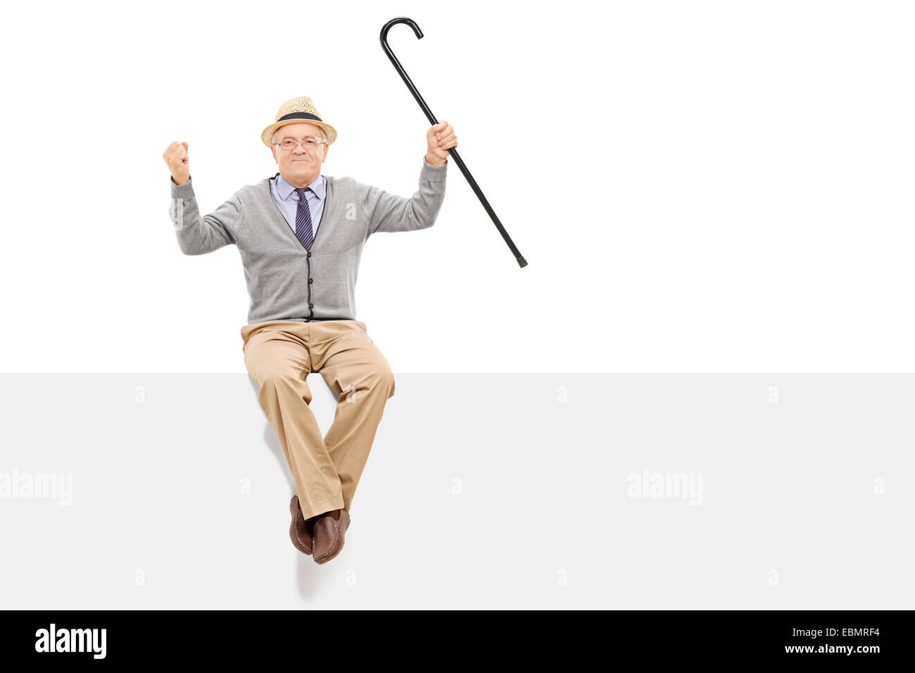 Happy senior holding a cane seated on a panel isolated on white ...