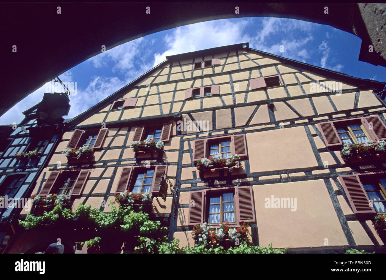 timbered house seen through an archway; worms eye view, France, Alsace ...