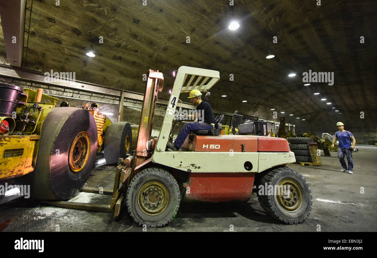 A worker lifts the wheel of a nine ton loader with a fork lift in the ...