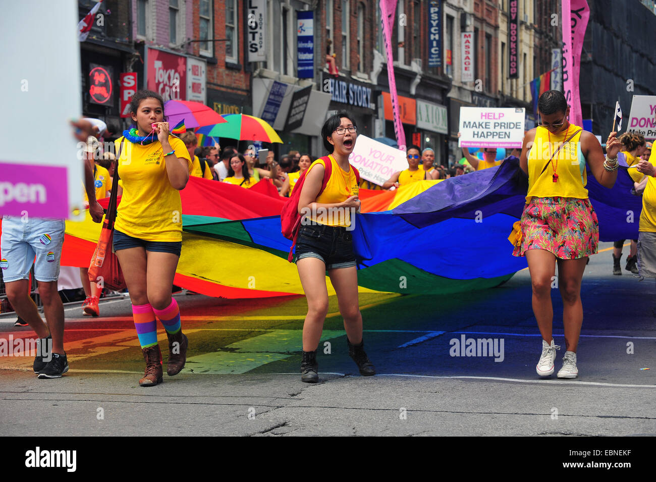 Volunteers carry a giant rainbow flag through the streets of Toronto ...