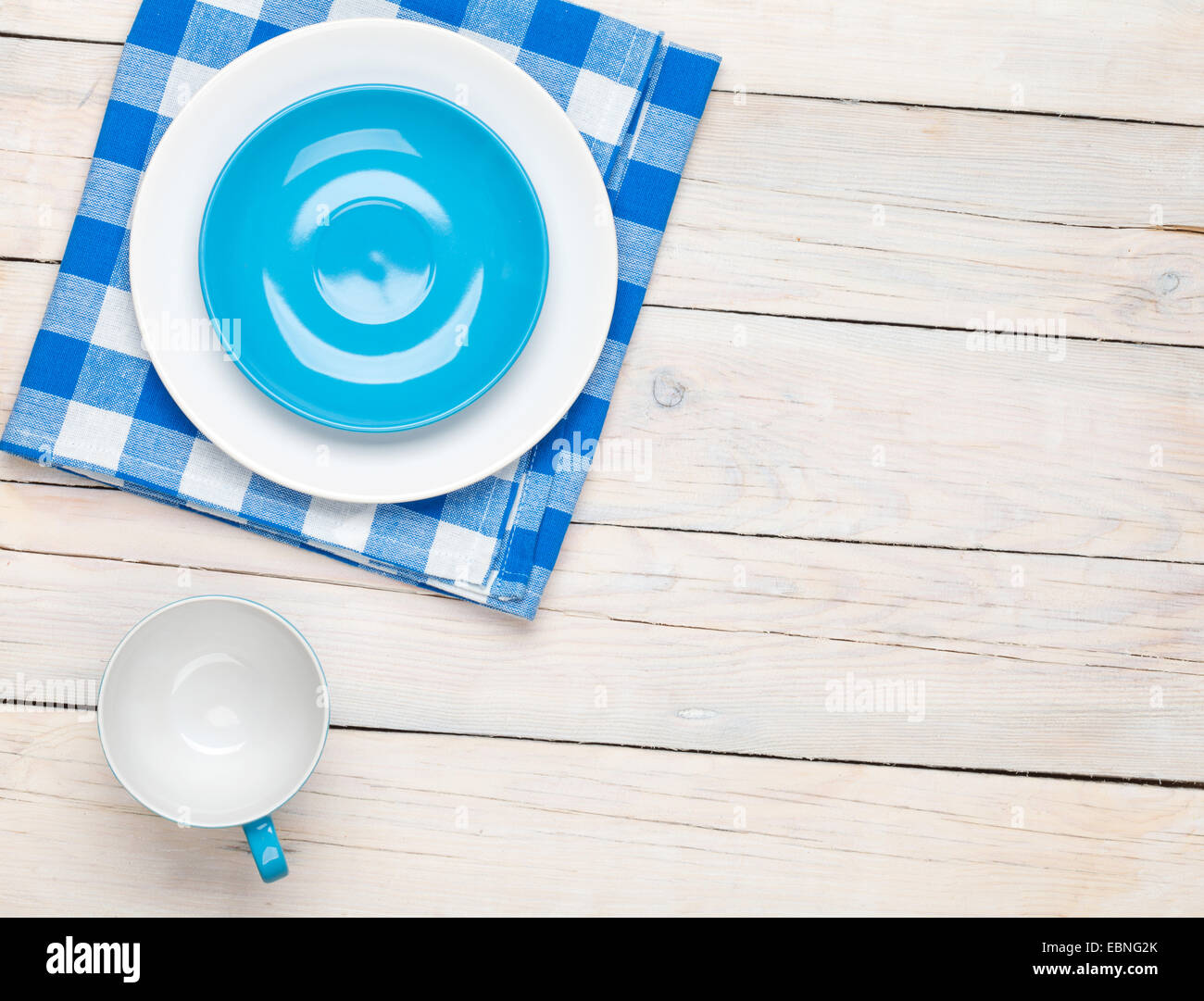 Empty plate, cup and towel over wooden table background. View from ...