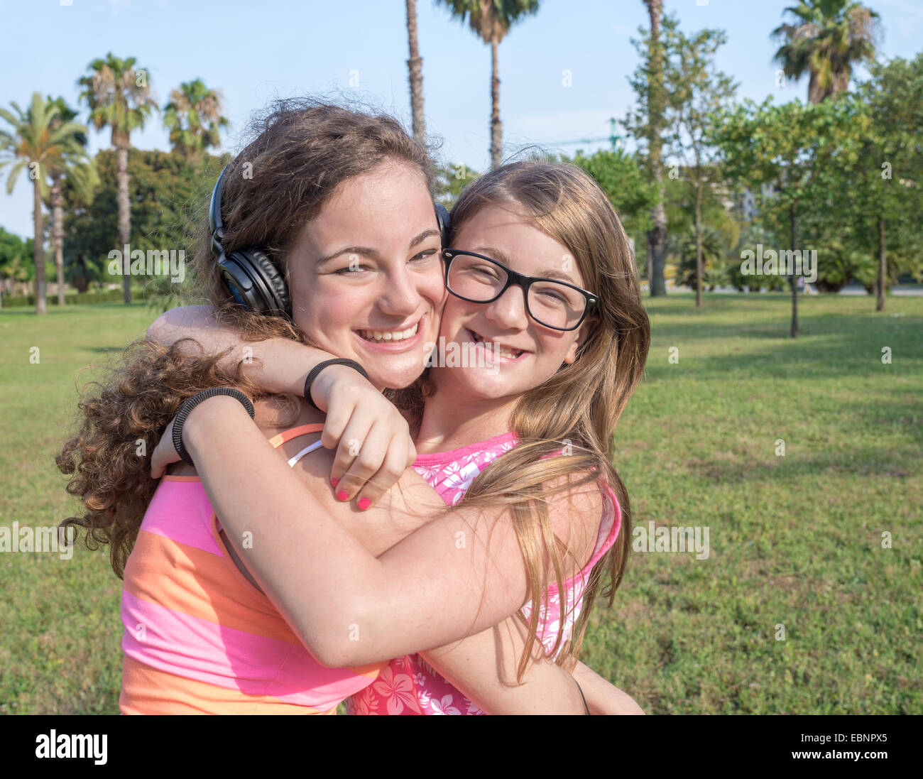Two girl goofing around and read on a lawn in park Stock Photo - Alamy