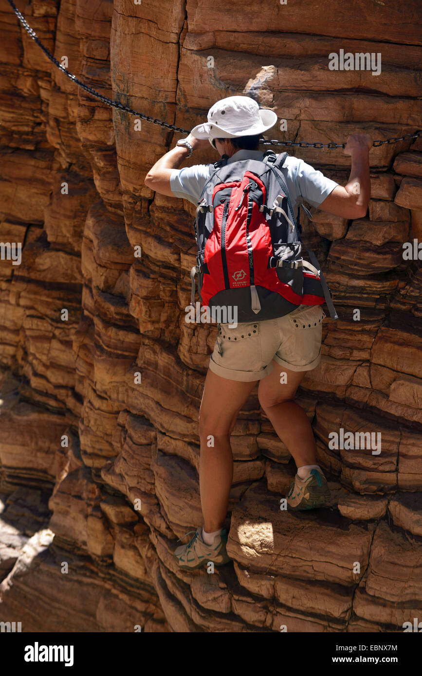female wanderer climbing at a rock wall in the Naukluftberge Mountains ...