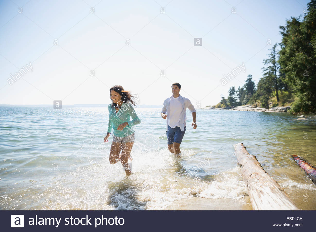 Couple splashing in ocean Stock Photo - Alamy