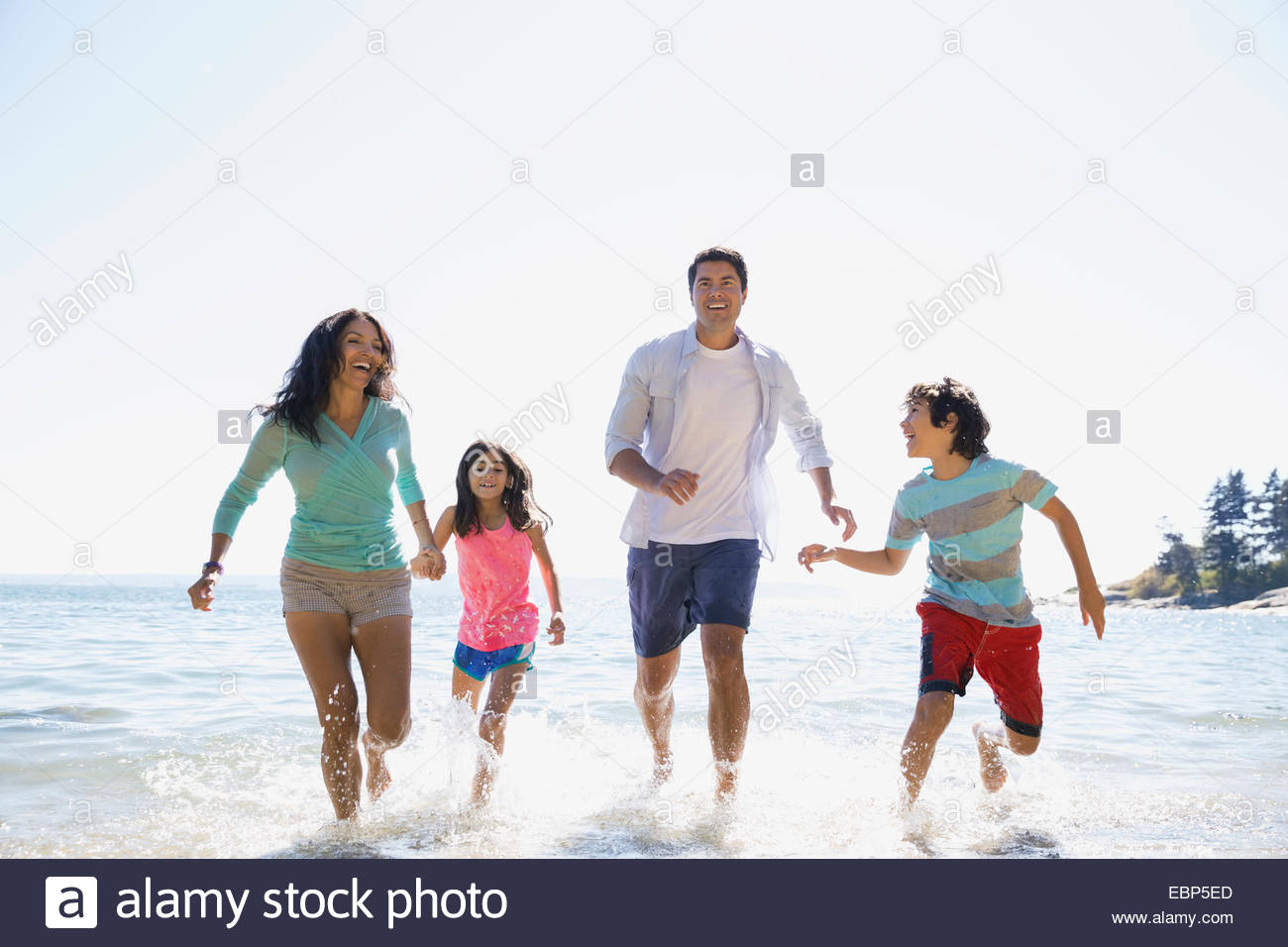 Family splashing in ocean Stock Photo - Alamy