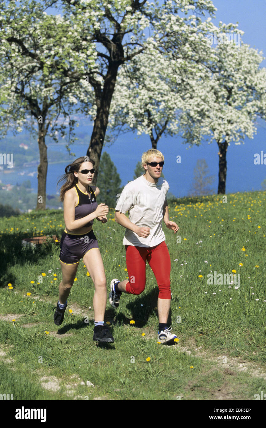 young pair jogging over field path in spring Stock Photo - Alamy