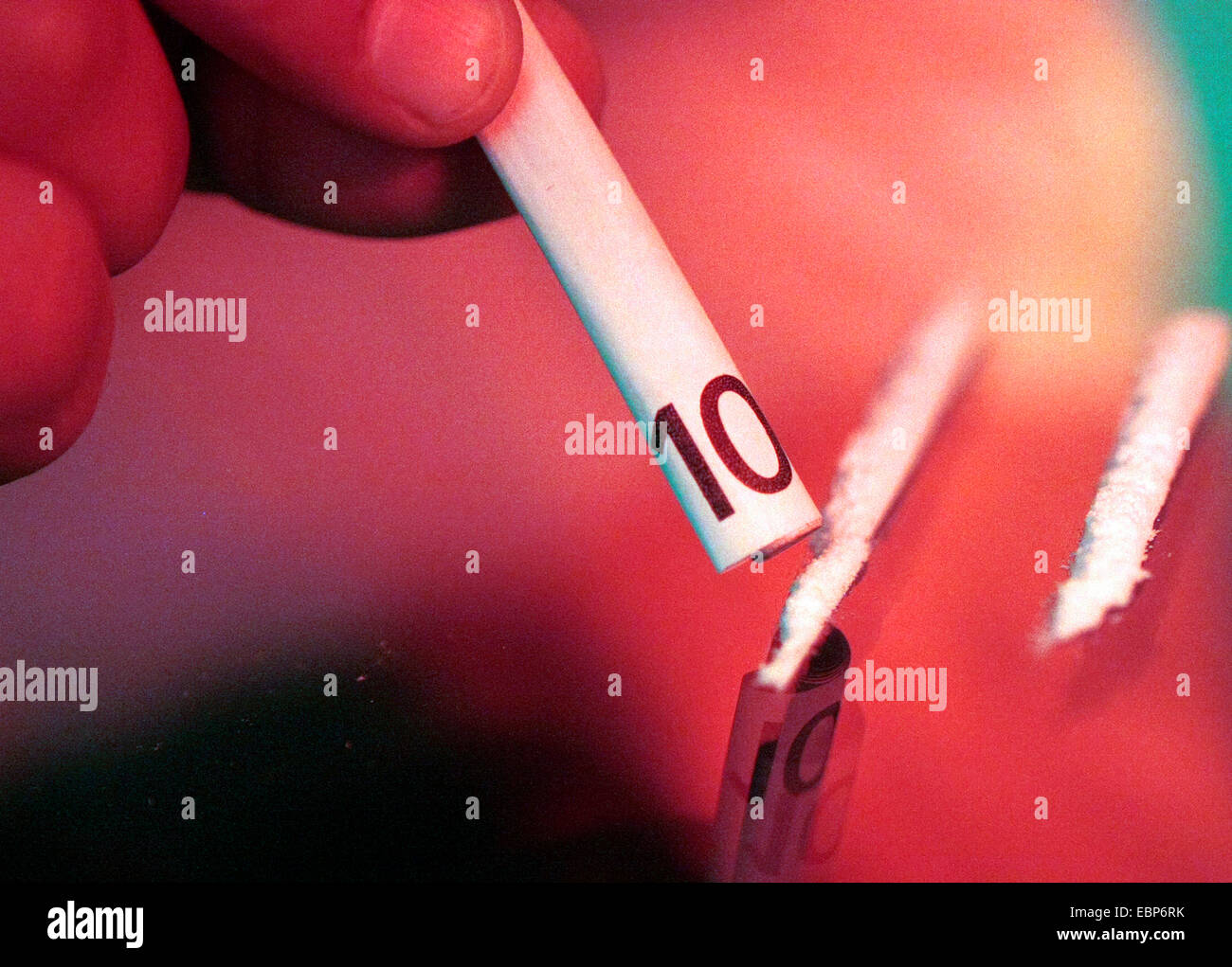 drug consumer snorting through a rolled 10 Euro bill two cocaine lines ...