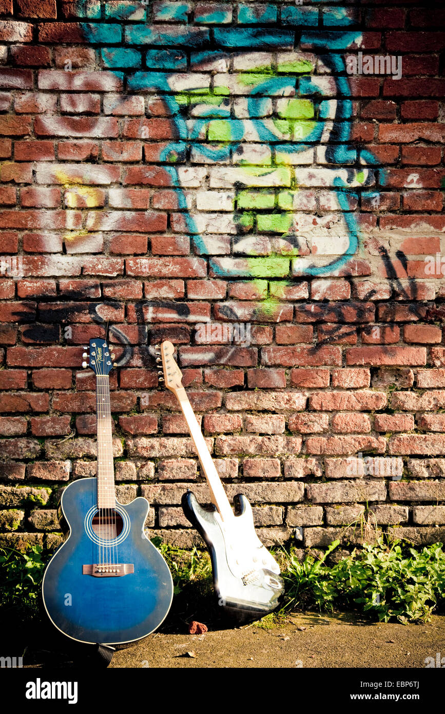 electric guitars leaning on a graffiti wall Stock Photo - Alamy
