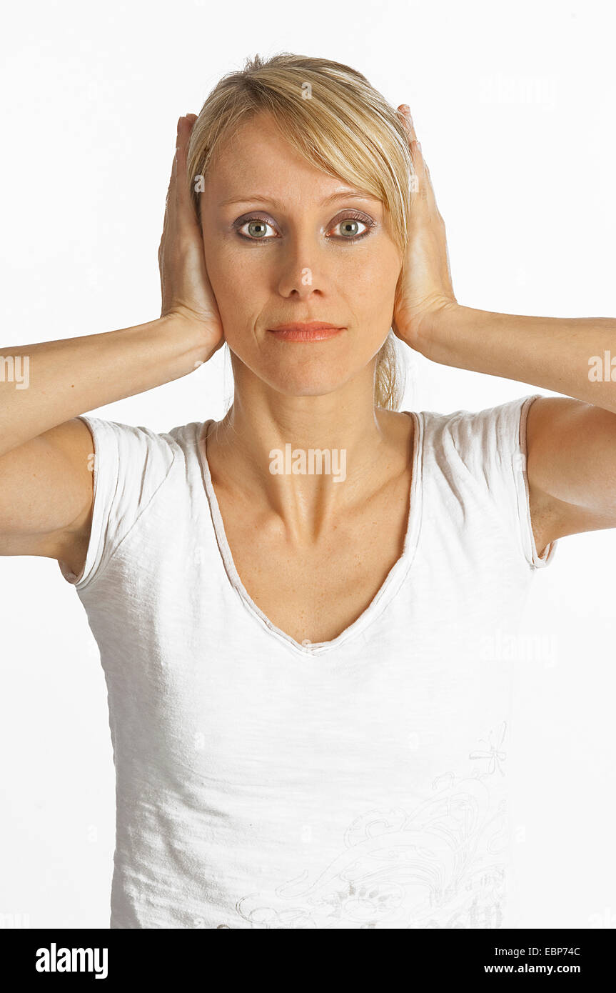 young blond woman keeping her ears shut Stock Photo - Alamy