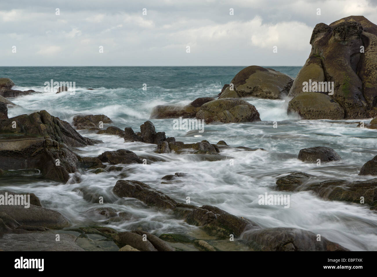 View of rocks and restless ocean on shore Stock Photo - Alamy
