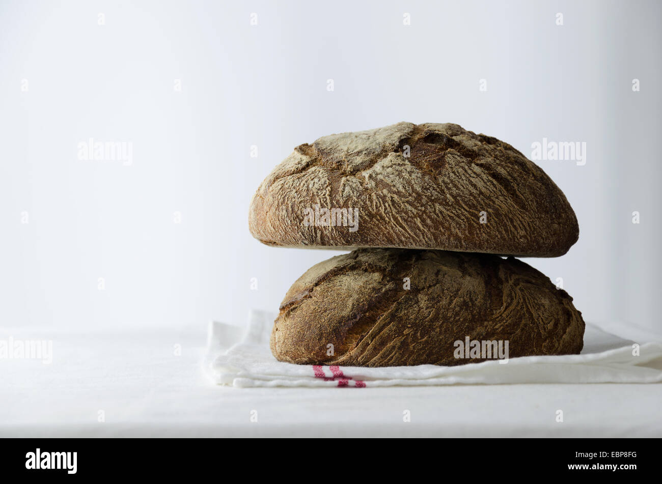 Traditional round bread over white cloth table Stock Photo - Alamy