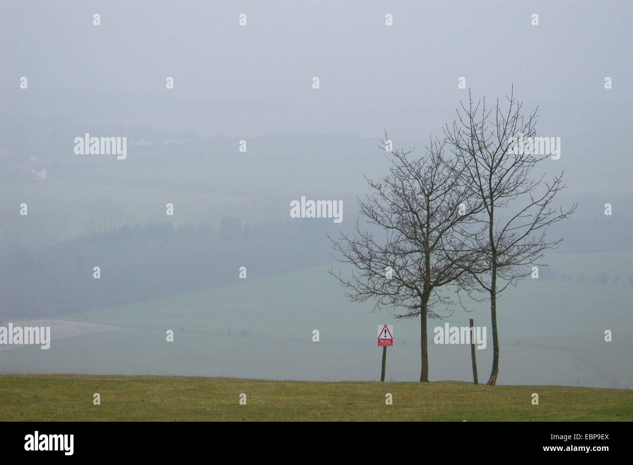 Two bare trees and warning sign near Dunstable in Bedfordshire, England ...