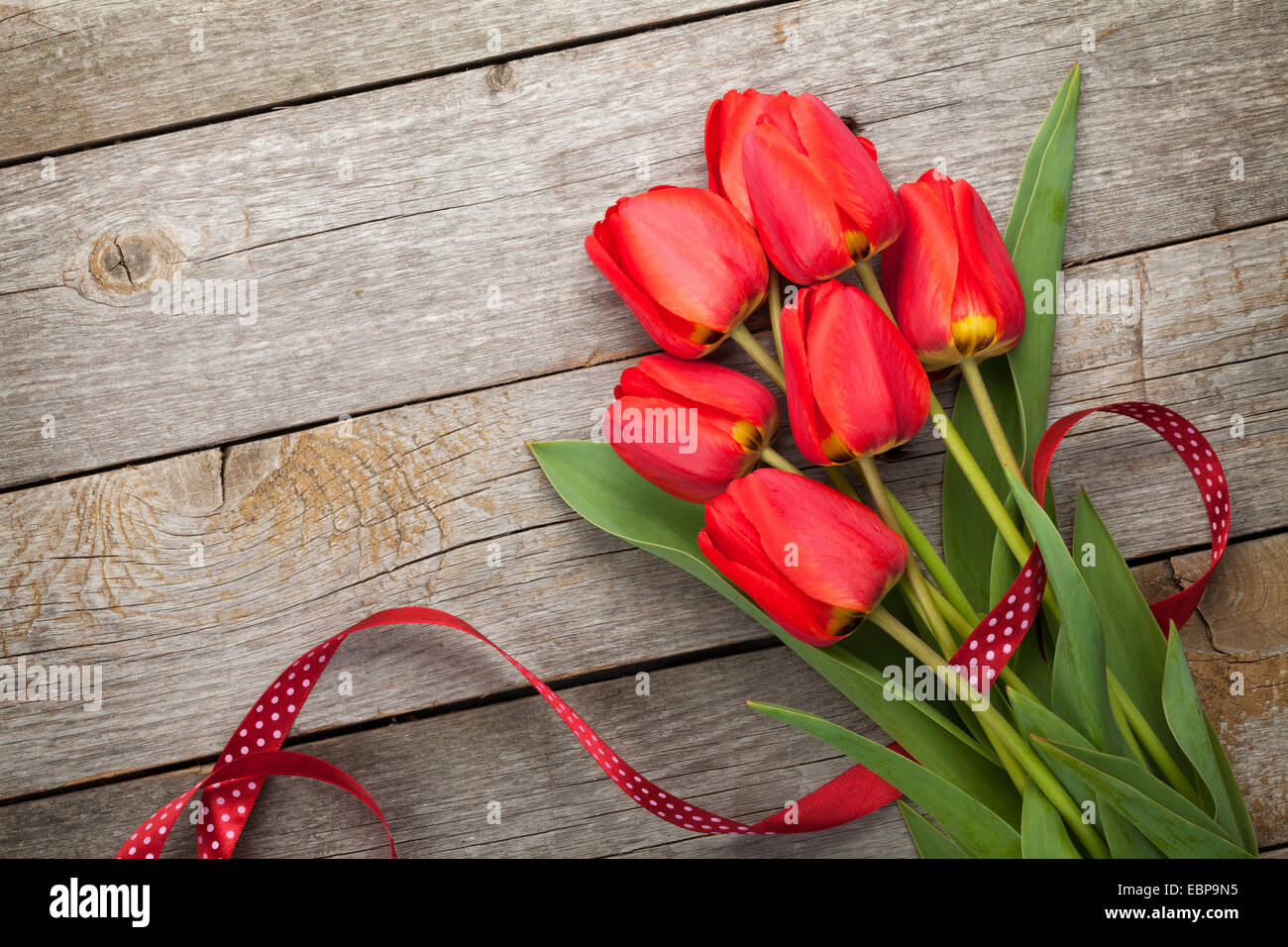 Fresh red tulips bouquet over wooden table background with copy space ...