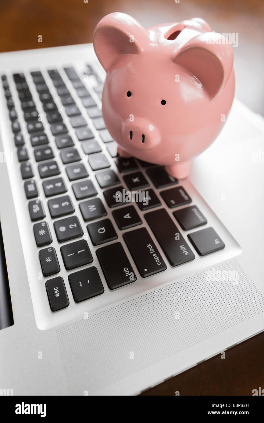 Piggy Bank Resting on Laptop Computer Keyboard Stock Photo - Alamy