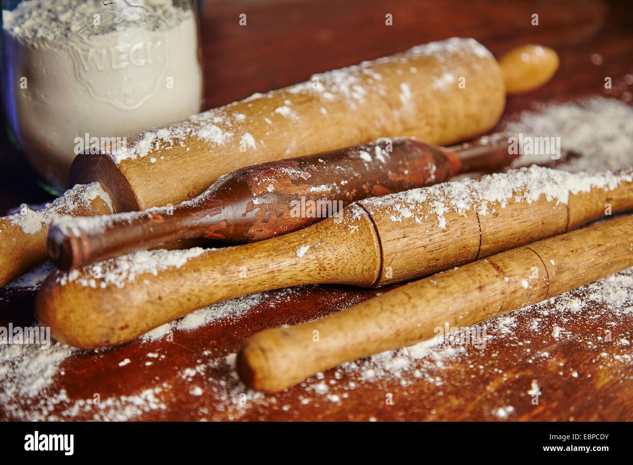 vintage rolling pins covered in flour over a wood table with a glass ...