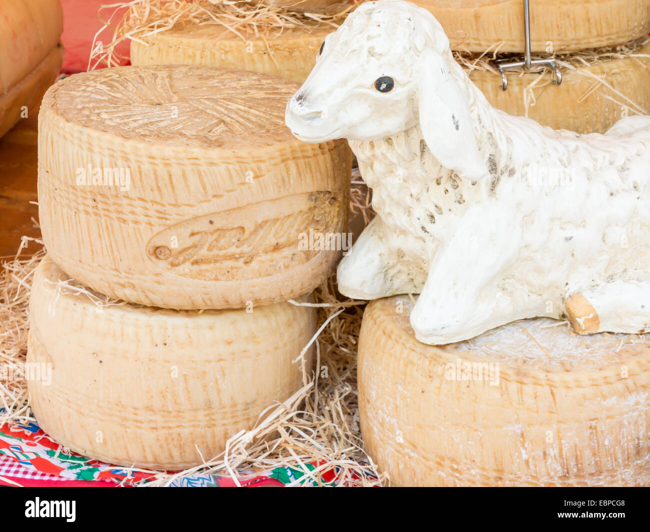 Stacked circular blocks of cheese with sheet statuette and straw Stock ...
