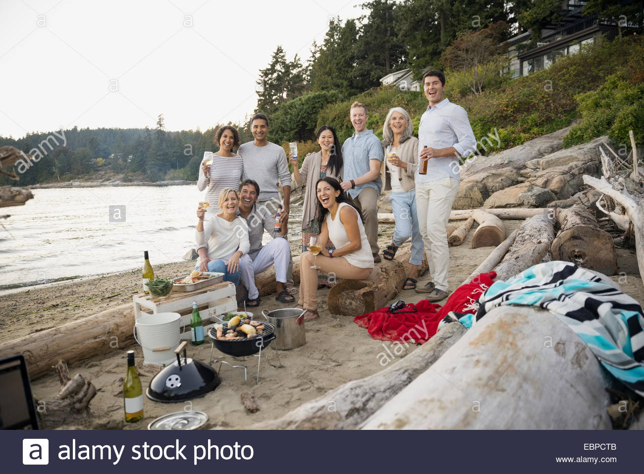 Friends enjoying clam bake on beach Stock Photo - Alamy