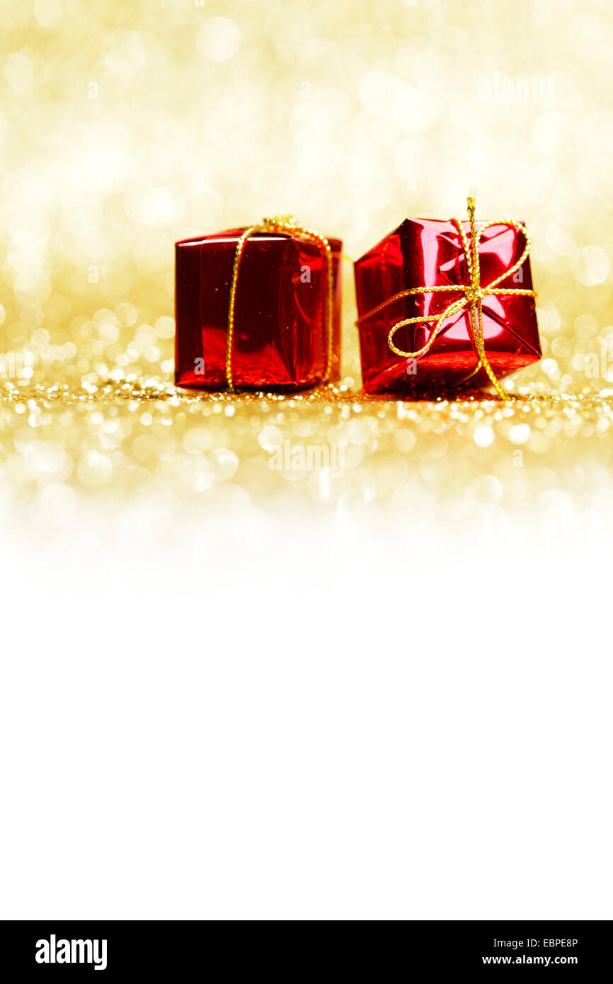 Small decorative red presents on golden glitter background Stock Photo ...