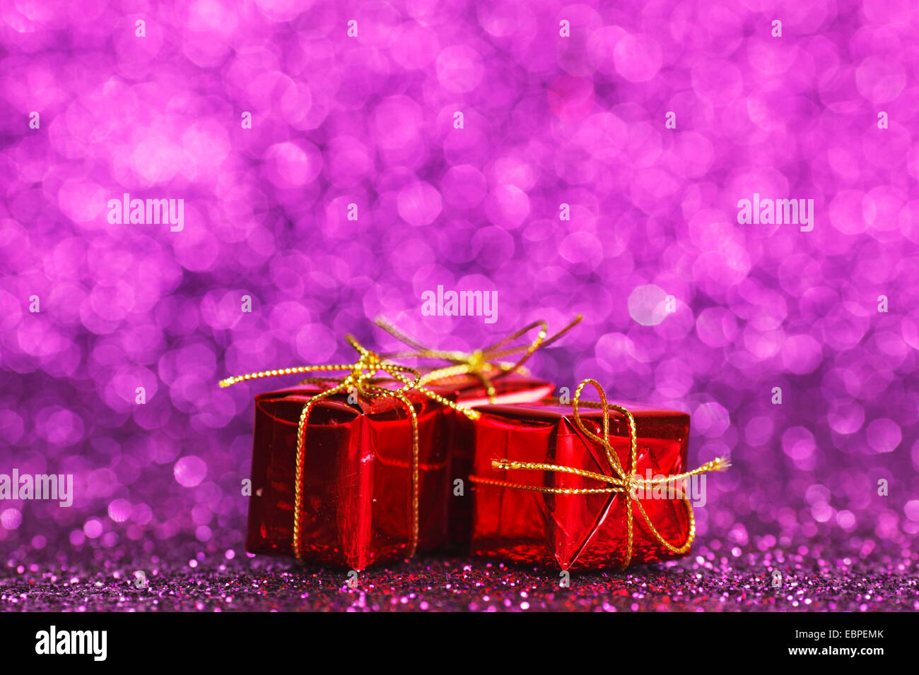 Small decorative gift boxes on shiny glitter background Stock Photo - Alamy