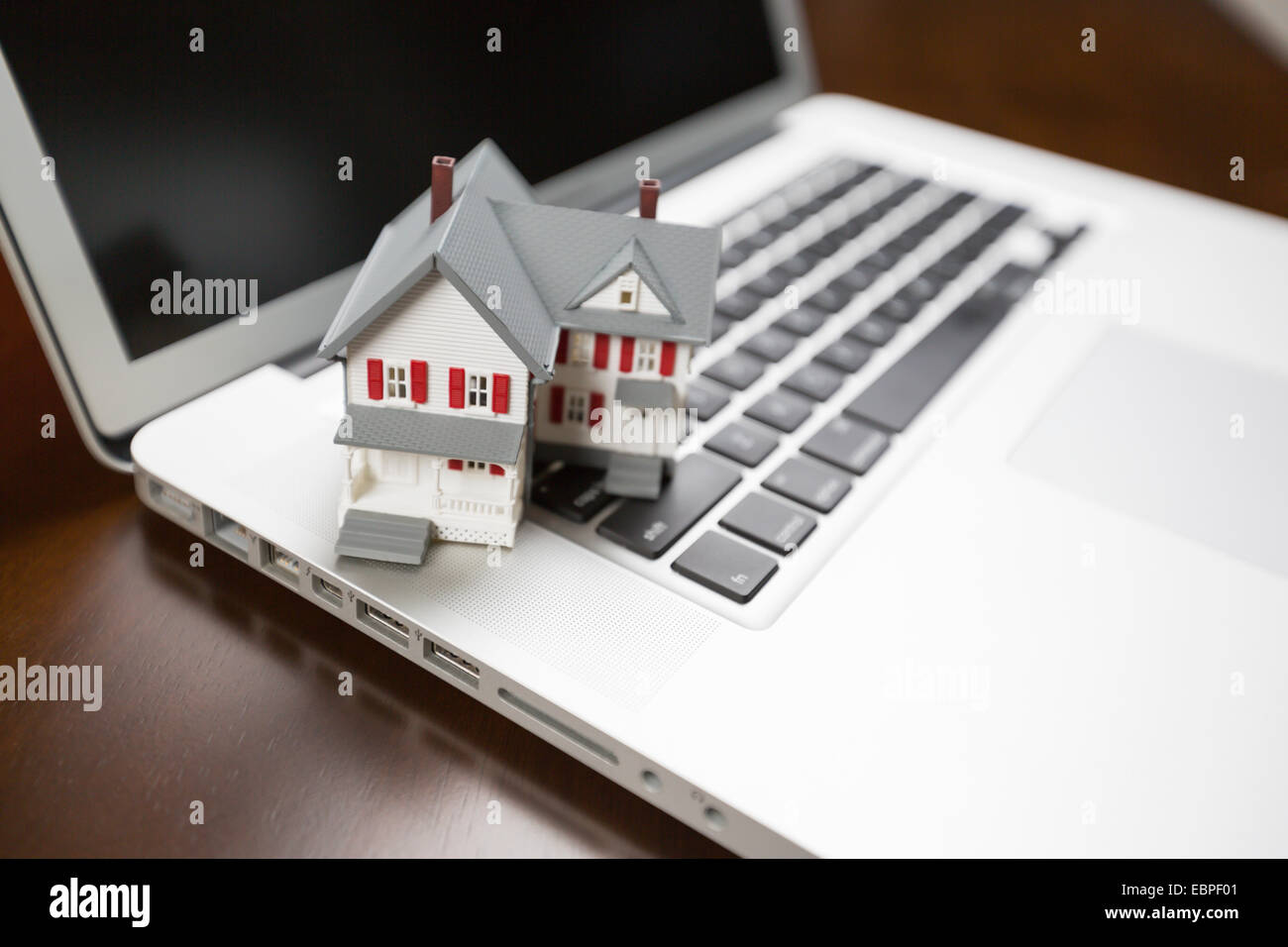 Miniature House And Laptop Computer Resting on Desktop Stock Photo - Alamy