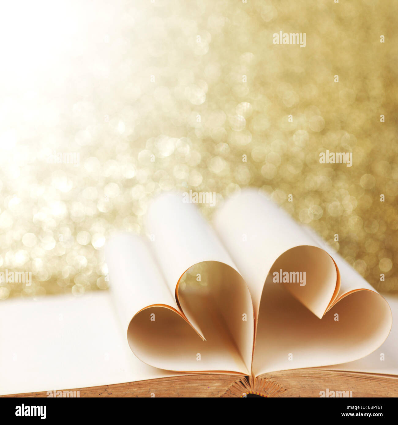 Heart shaped book pages on glitter background Stock Photo - Alamy