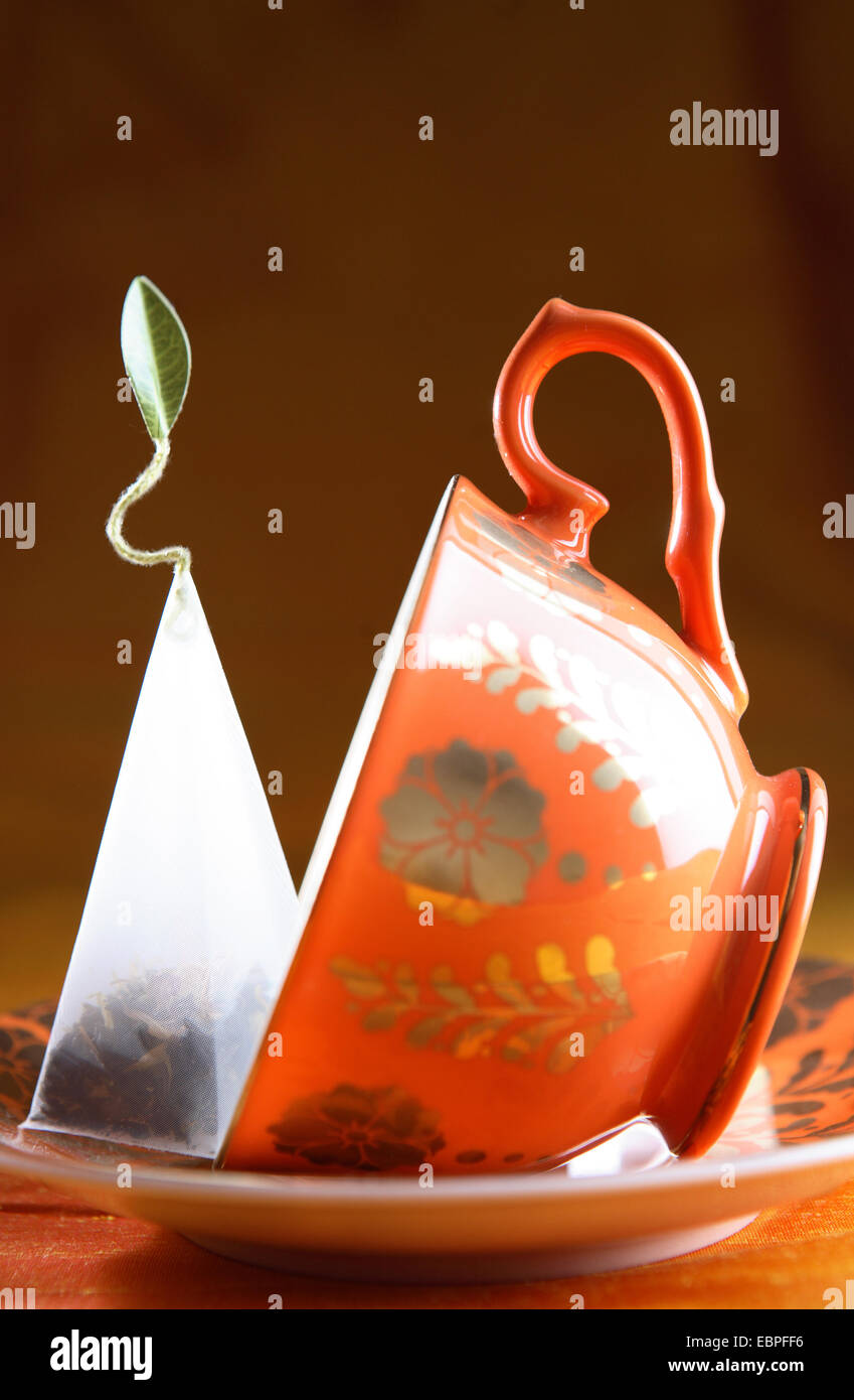 orange ornate teacup with decorative tea on a orange saucer with orange ...