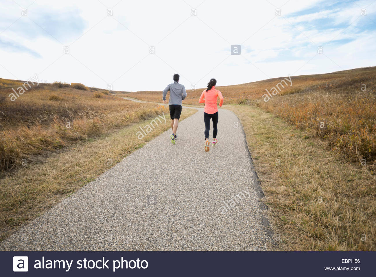 Couple running on rural path Stock Photo - Alamy