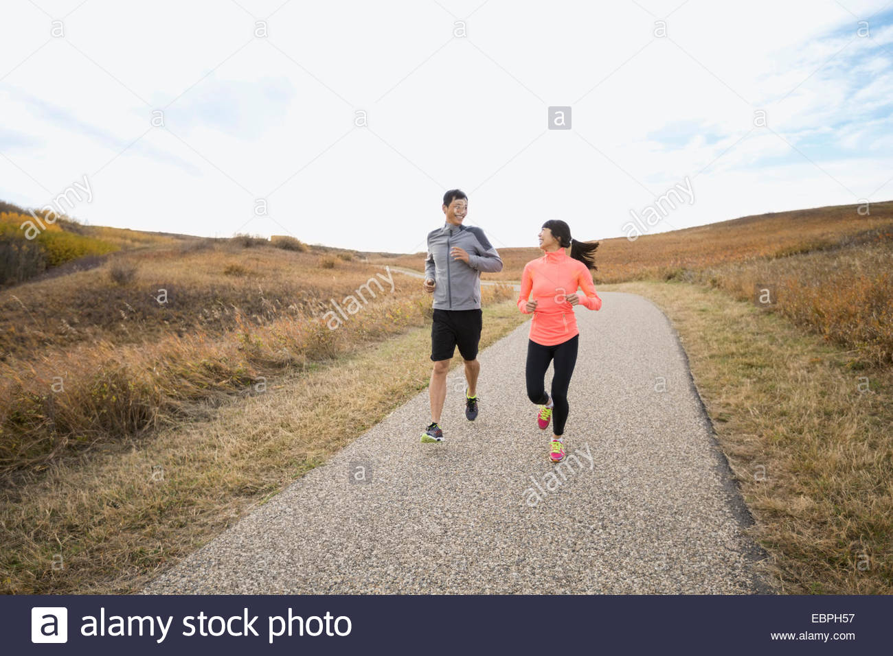 Couple running on rural path Stock Photo - Alamy