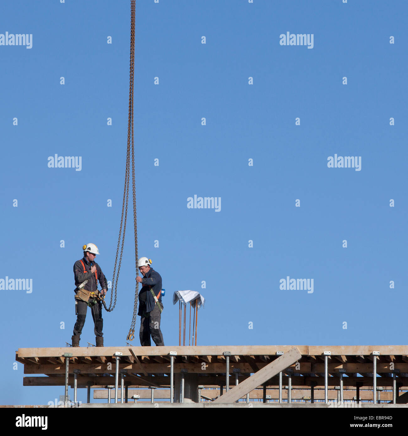 construction workers on roof of new building with blue sky Stock Photo ...