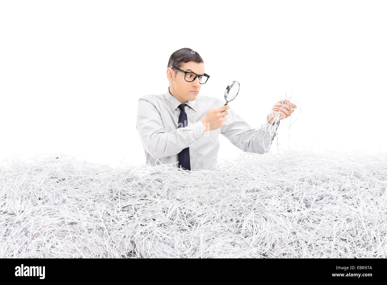 Angry man examining a pile of shredded paper isolated on white ...
