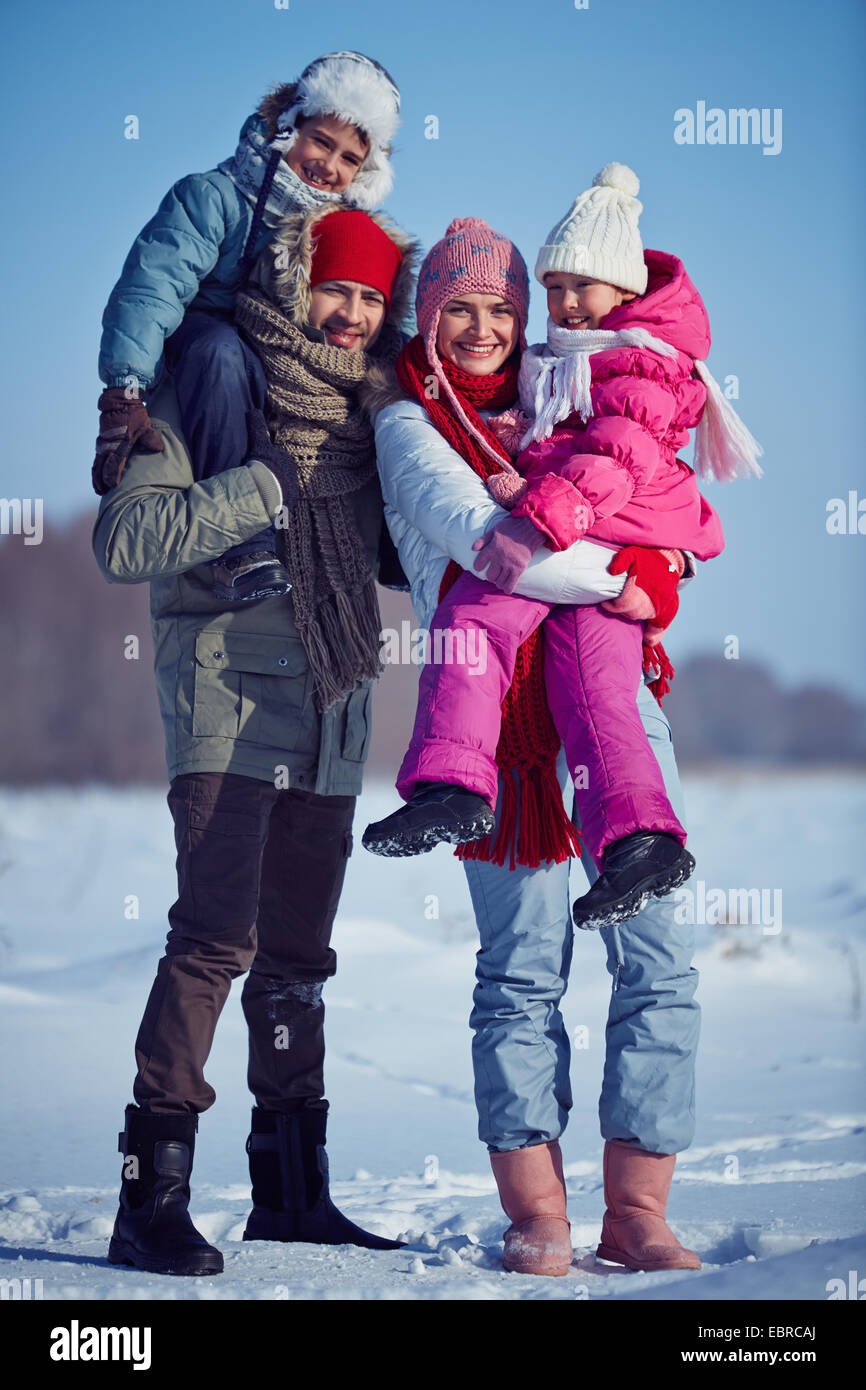 Happy parents and their kids standing on snow Stock Photo - Alamy