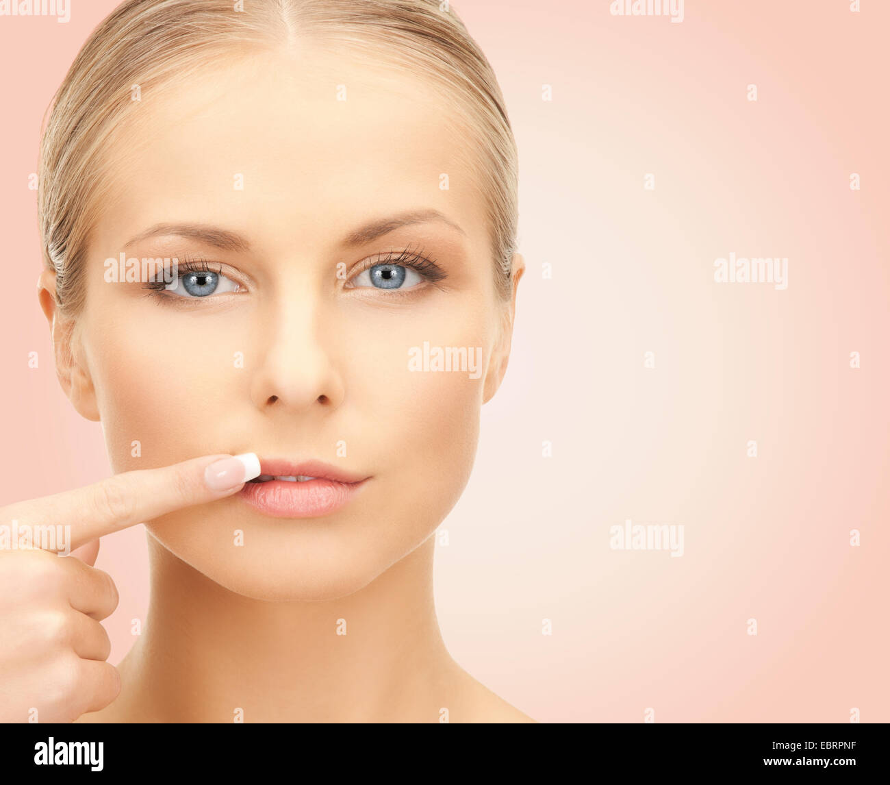 beautiful young woman pointing finger to her lips Stock Photo - Alamy
