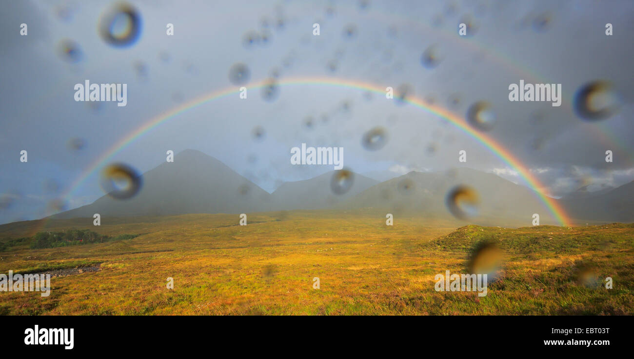 view through a wet window to a rainbow in the Scottish Highlands ...