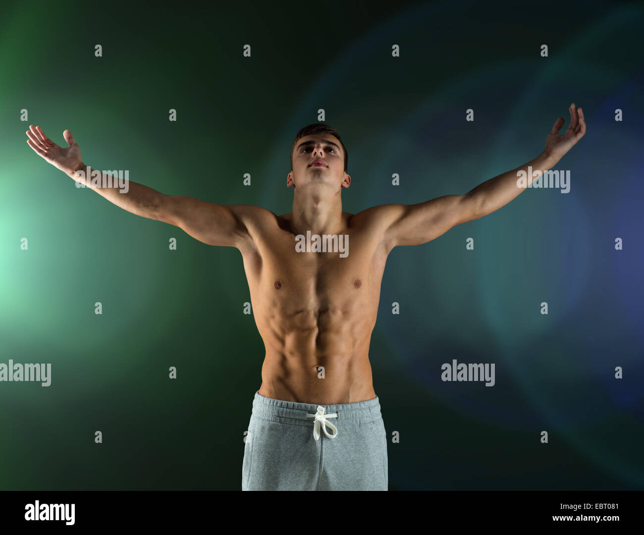 young male bodybuilder with raised hands Stock Photo - Alamy