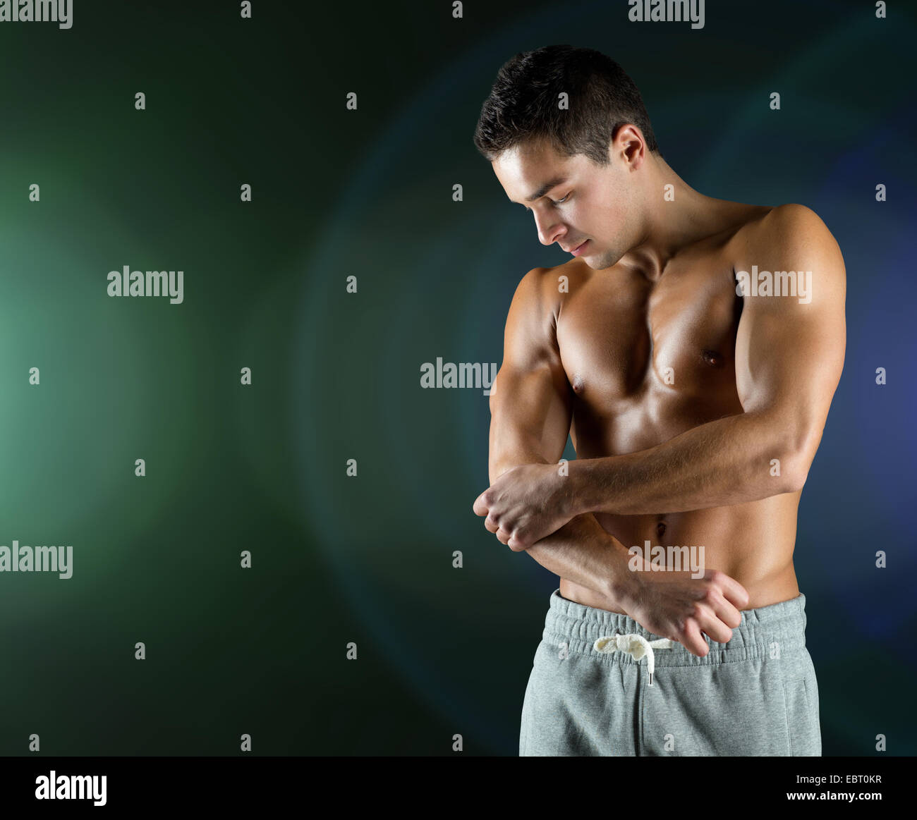 young male bodybuilder injured touching elbow Stock Photo - Alamy
