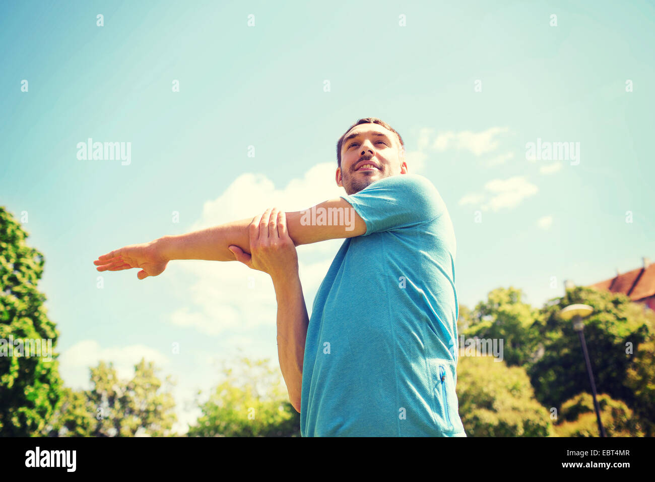 smiling man stretching outdoors Stock Photo - Alamy