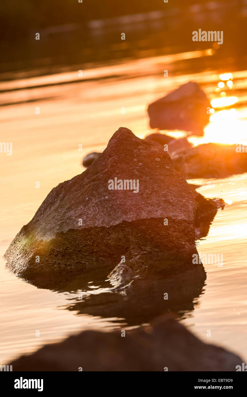 Beautiful sunset with rocks over the lake Stock Photo - Alamy