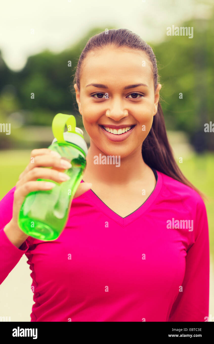 smiling woman drinking from bottle Stock Photo - Alamy