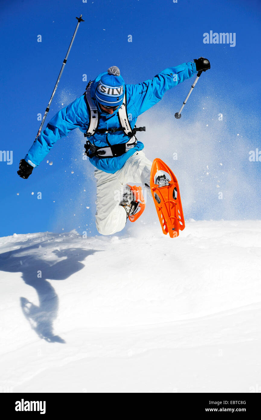 man with snow shoes jumping over a snow-covered slope, France Stock ...