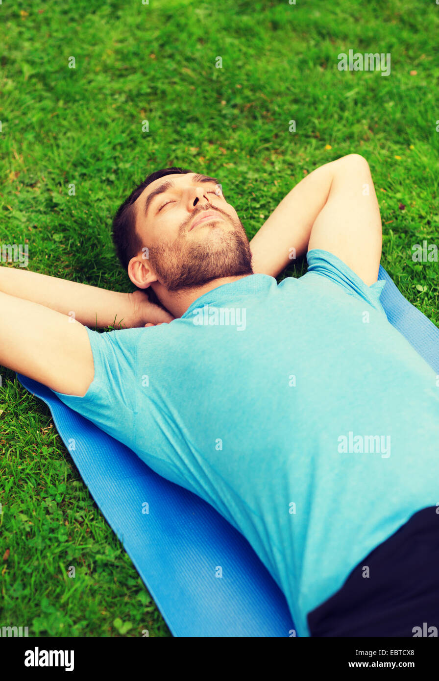smiling man lying on mat outdoors Stock Photo - Alamy